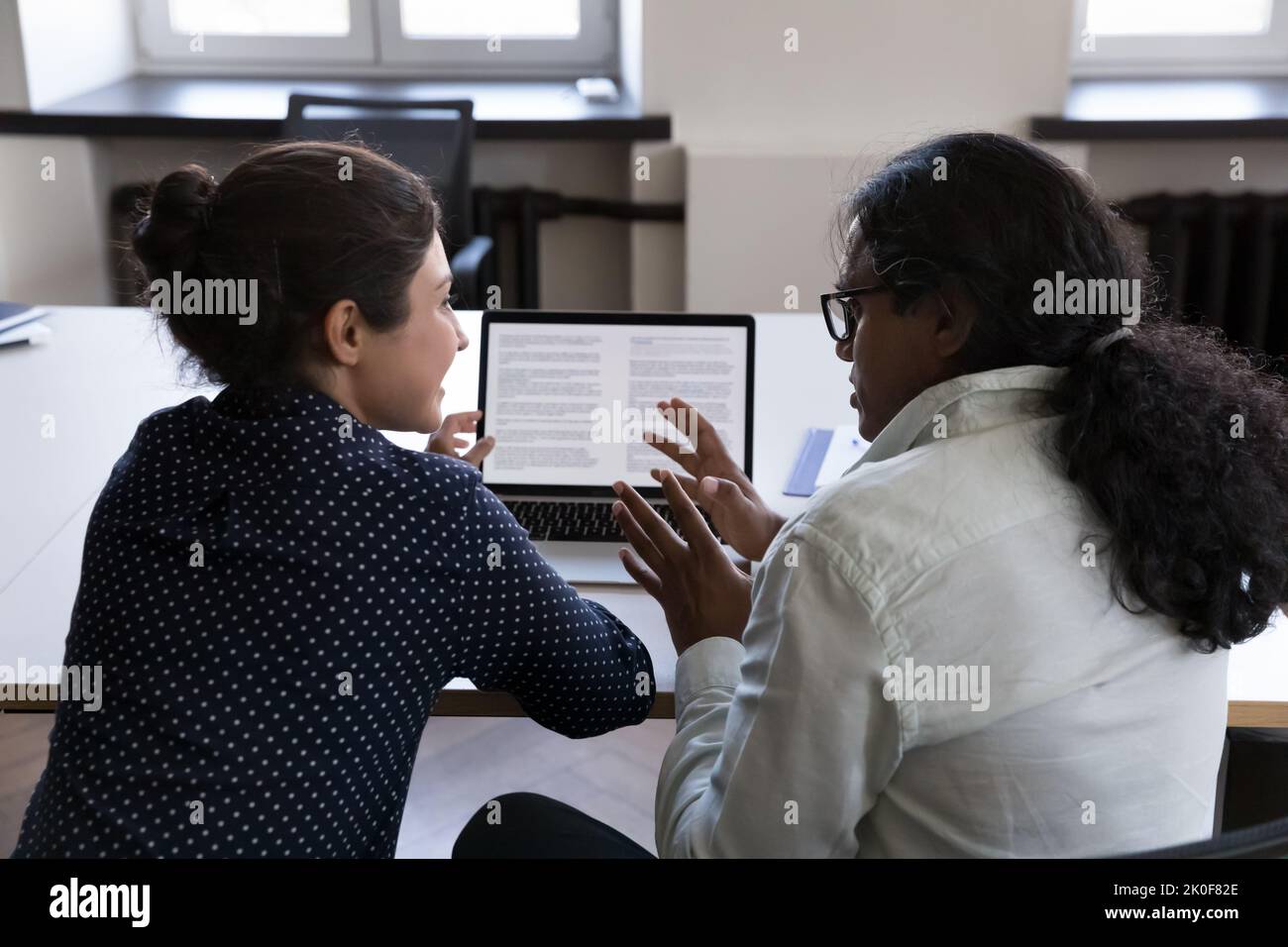 Two Indian office employees sharing laptop at work table Stock Photo ...