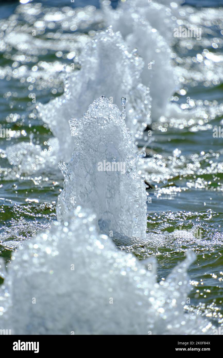 Foam jets of water and shine of sunlight from the fountain bright sunny ...