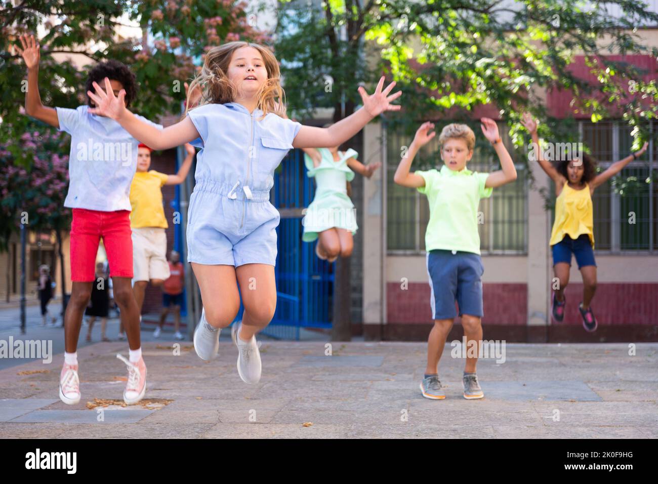 Group of positive playful kids jumping outdoors Stock Photo - Alamy