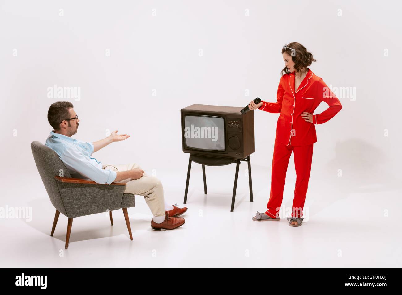 Portrait of couple spending time together, man watching Tv and woman ...