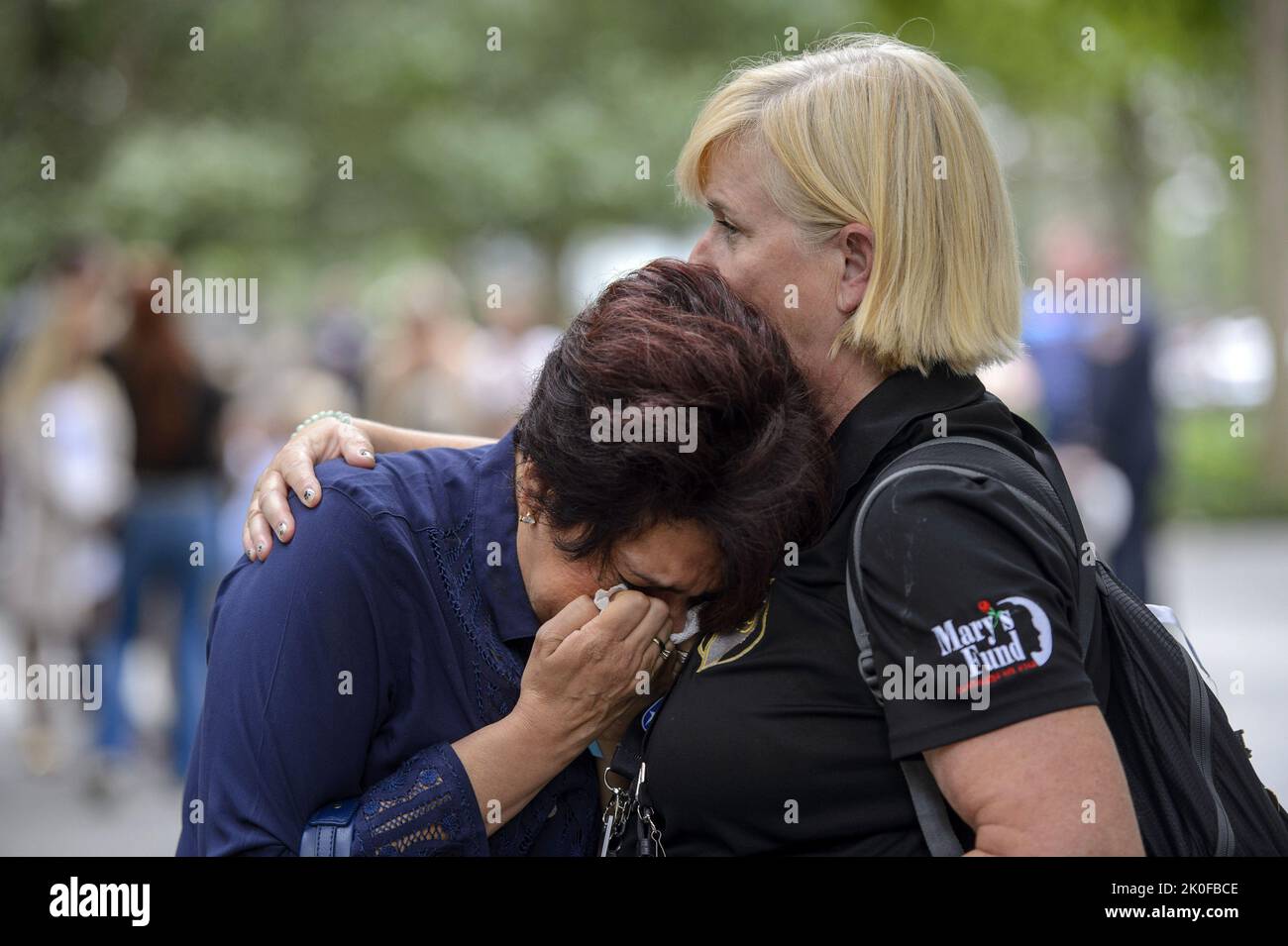 New York, United States. 11th Sep, 2022. A crying woman is comforted ...