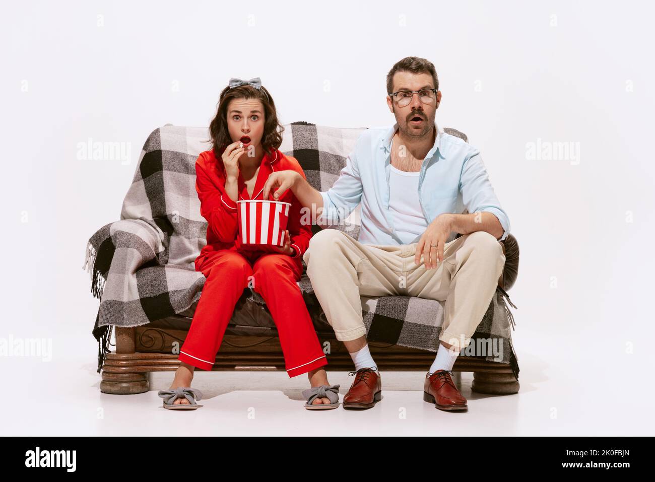 Portrait of couple, man and woman watching TV, movie together with ...