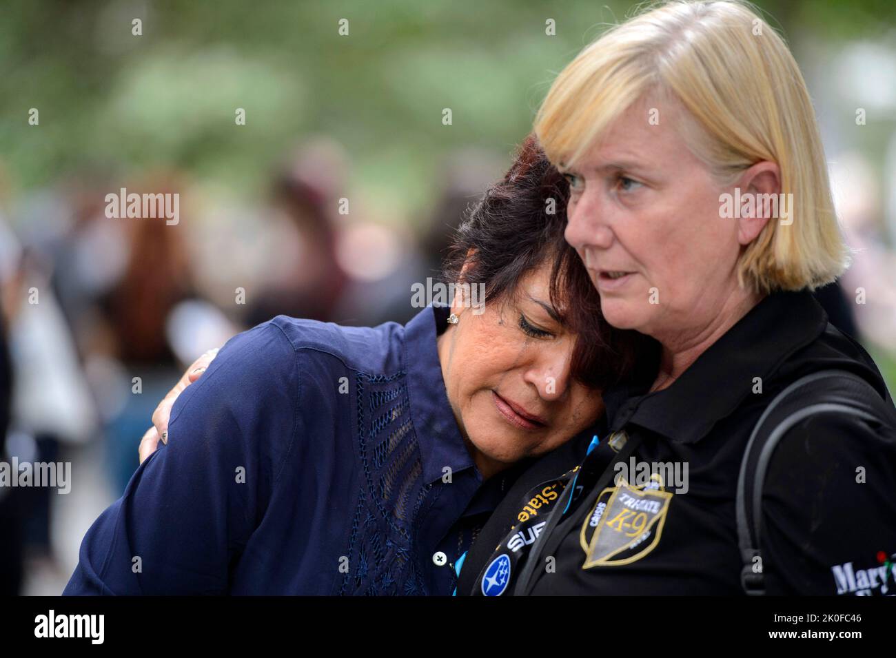 A crying woman is comforted during a ceremony to commemorate the ...
