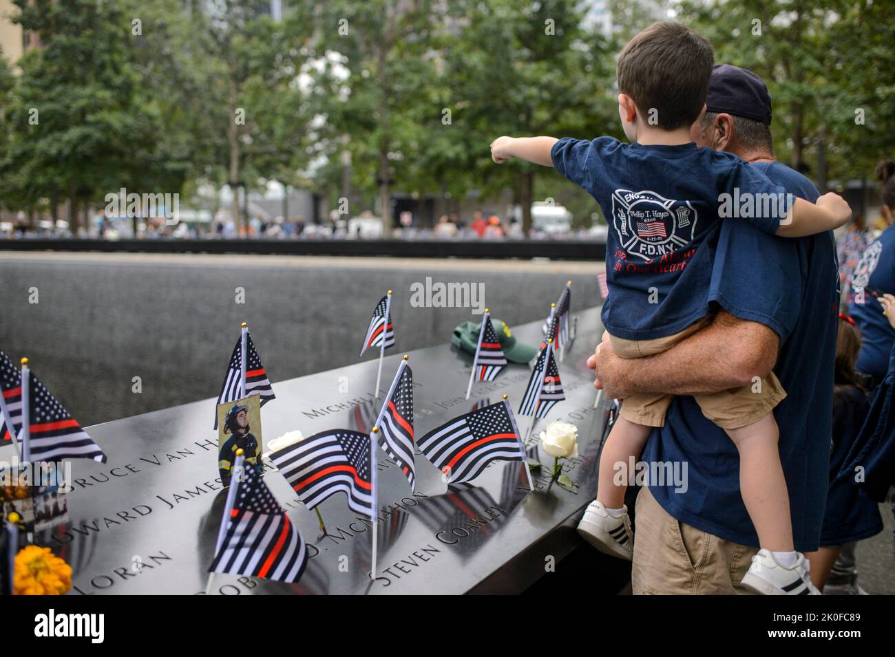 A boy points towards the center of the National September 11th Memorial ...