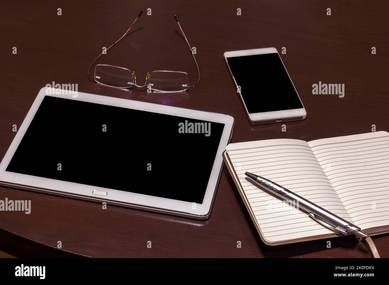 Office table: mobile phone, tablet, glasses, notebook and pen with copy ...