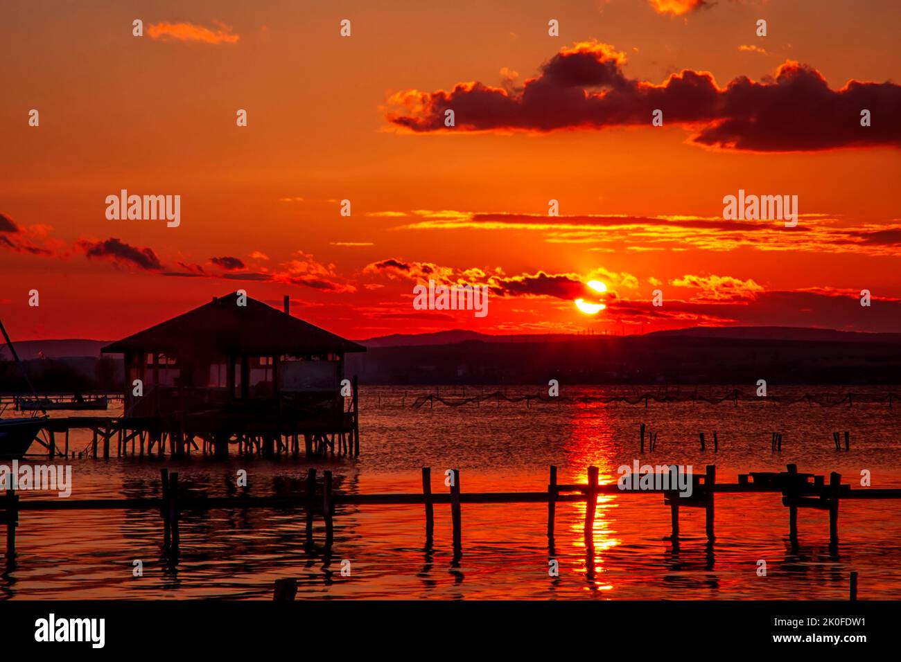 Exciting long exposure landscape on a lake with a wooden small house in ...