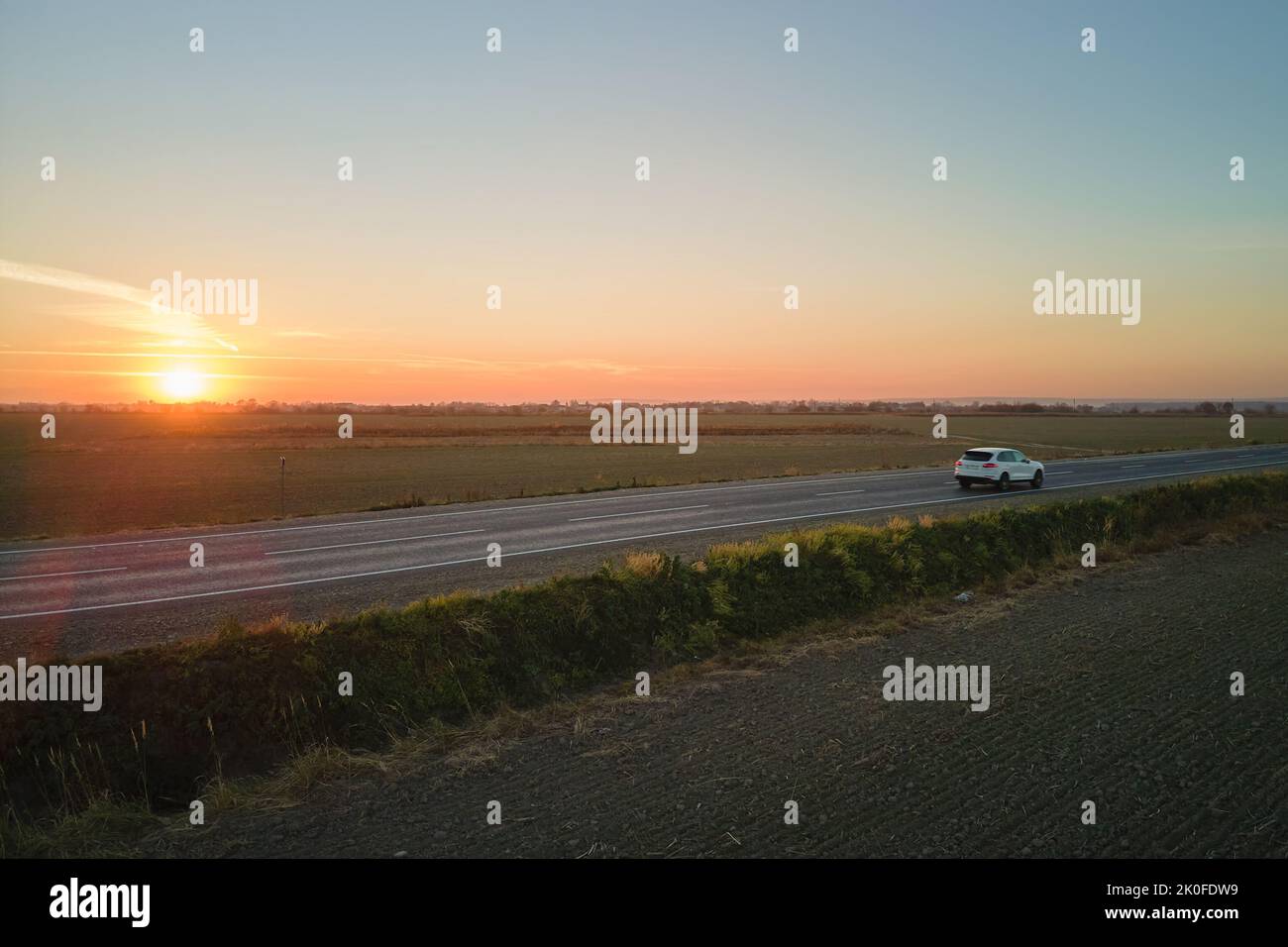 Aerial view of intercity road with blurred fast driving car at sunset ...