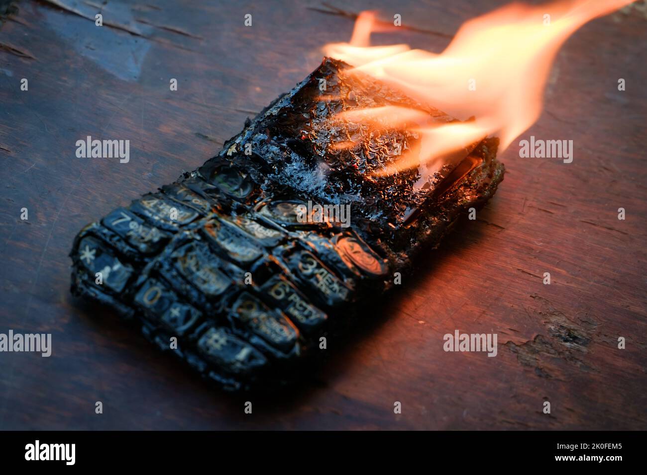 mobile phone lies on the table and burns with a bright flame Stock ...
