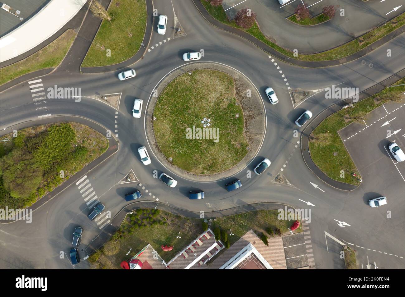 Aerial view of road roundabout intersection with fast moving heavy traffic. Urban circular ...