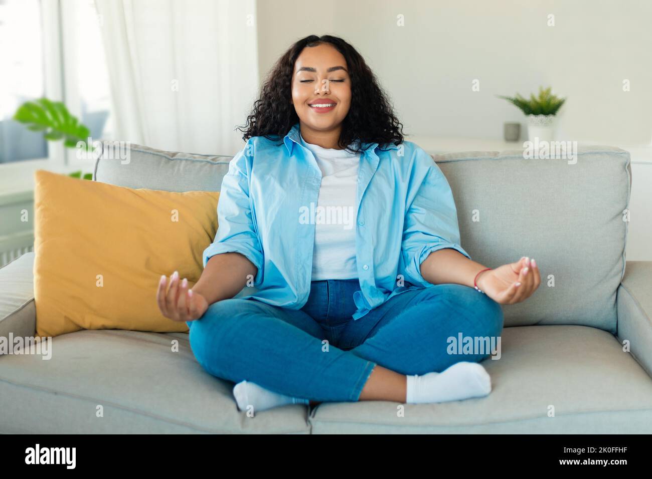 African American Lady Meditating With Eyes Closed Sitting At Home Stock ...