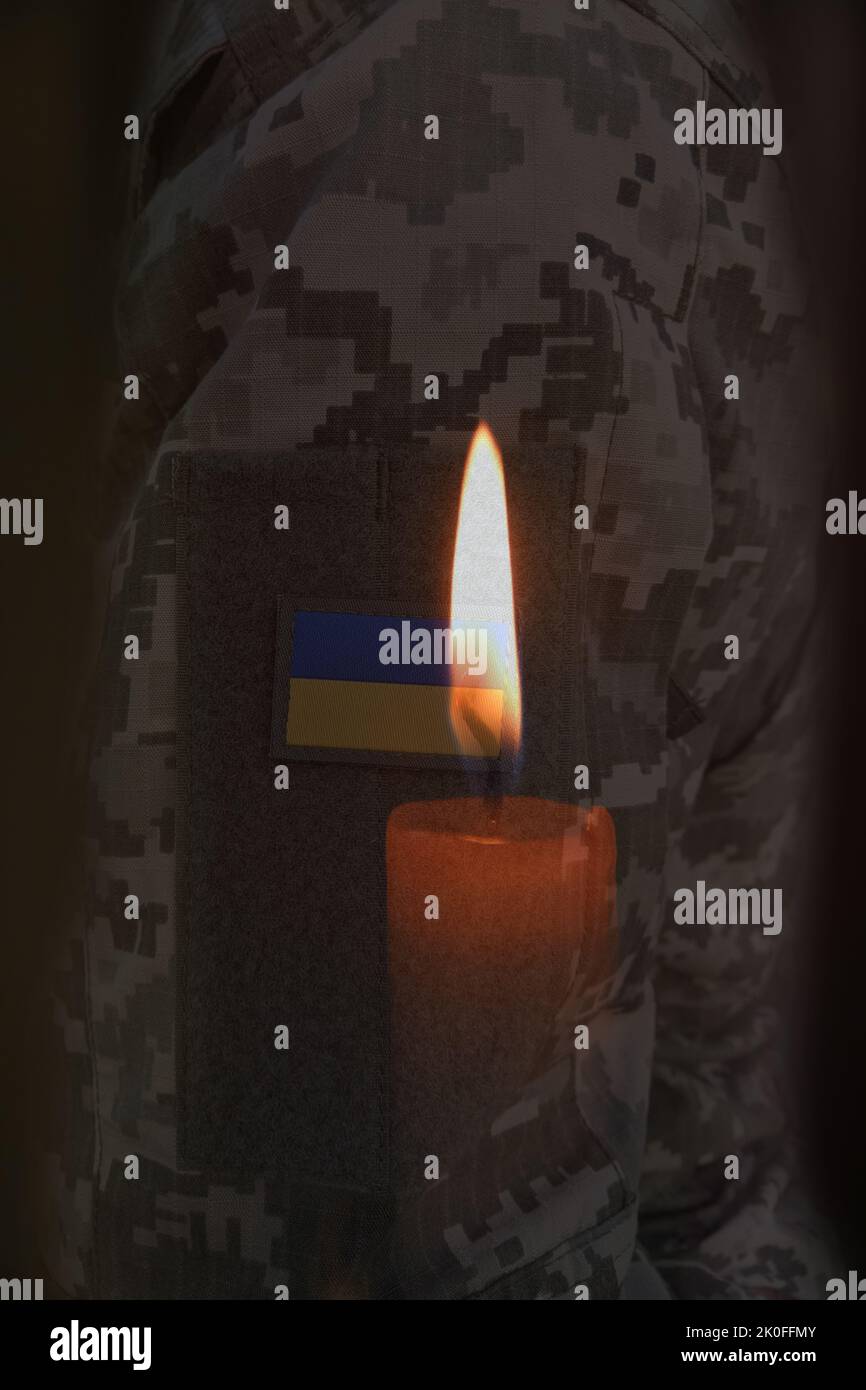 Defocus close up single candle light and flame on army Ukraine soldier ...