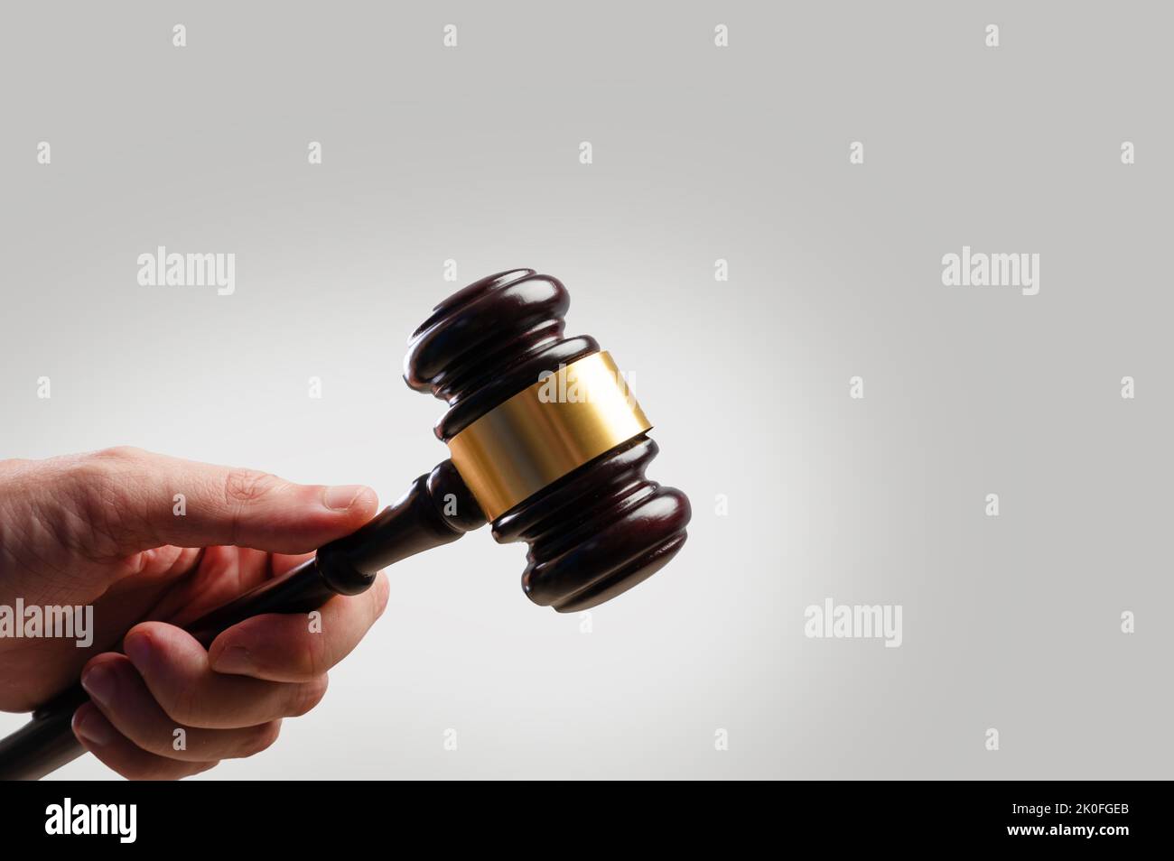 Wooden gavel of the judge in the hand of a man. Isolated on white ...