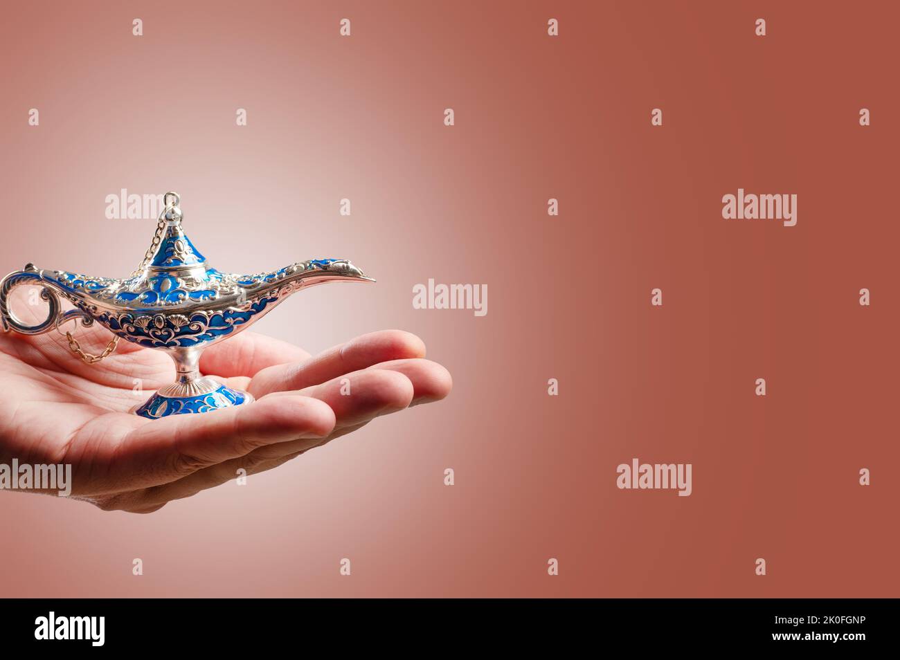 Magic lamp of Aladdin in a female hand on a beige background. Magic ...