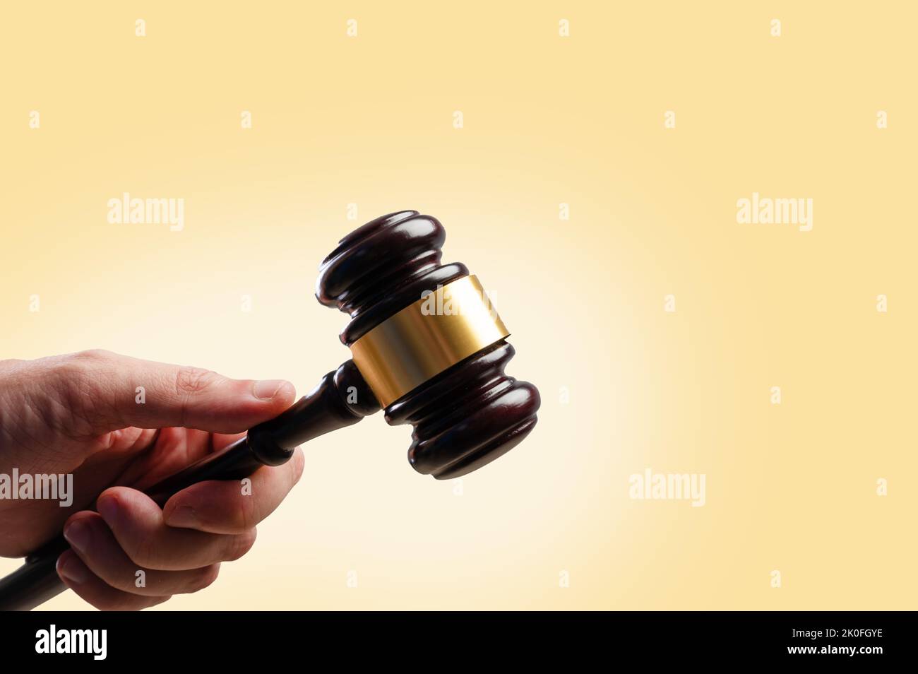 Judgment and Justice. Wooden judge's gavel in a man's hand on a beige ...