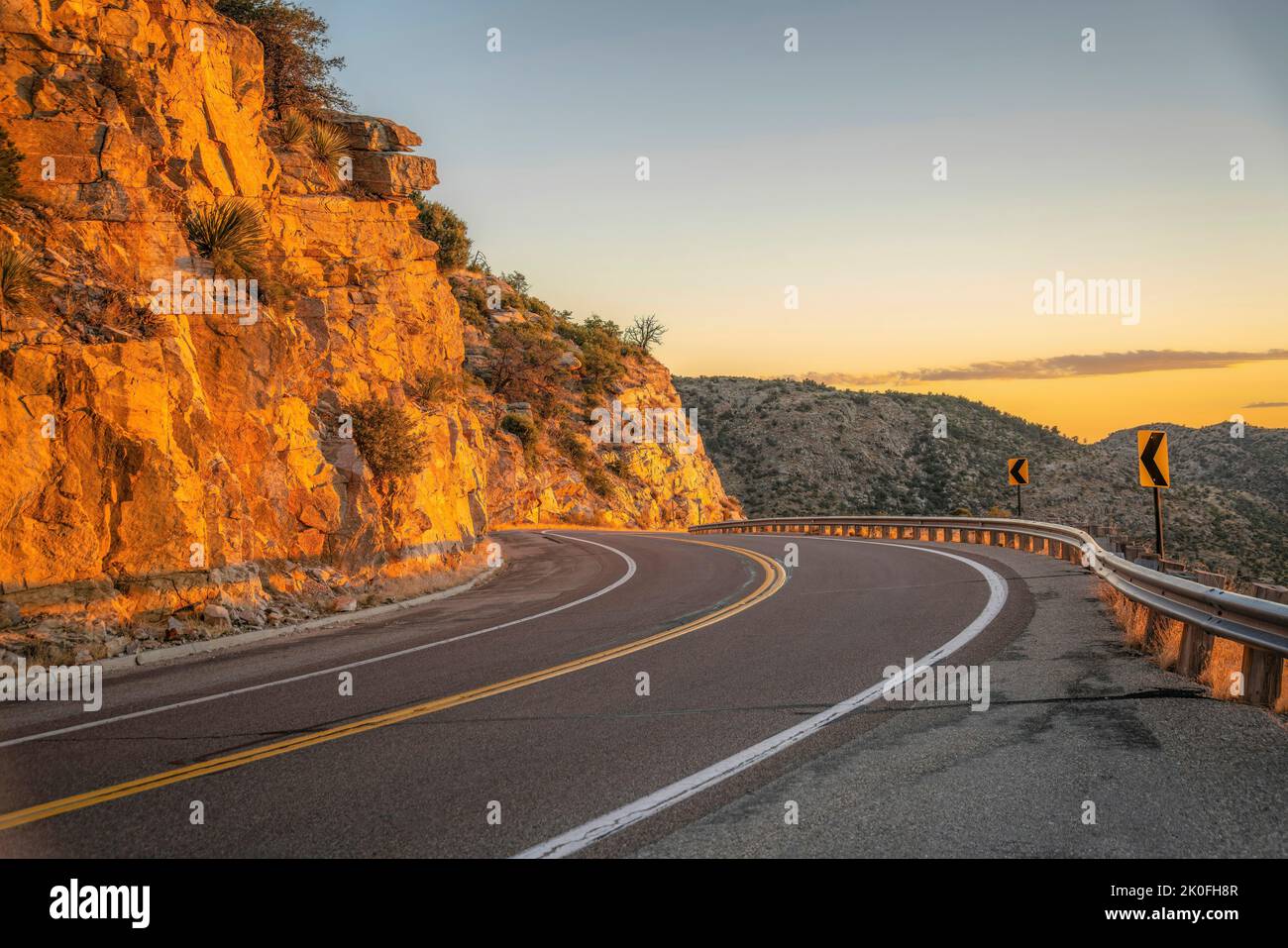 Drive up a winding road along rocky cliffs at sunset in Mount Lemmon ...