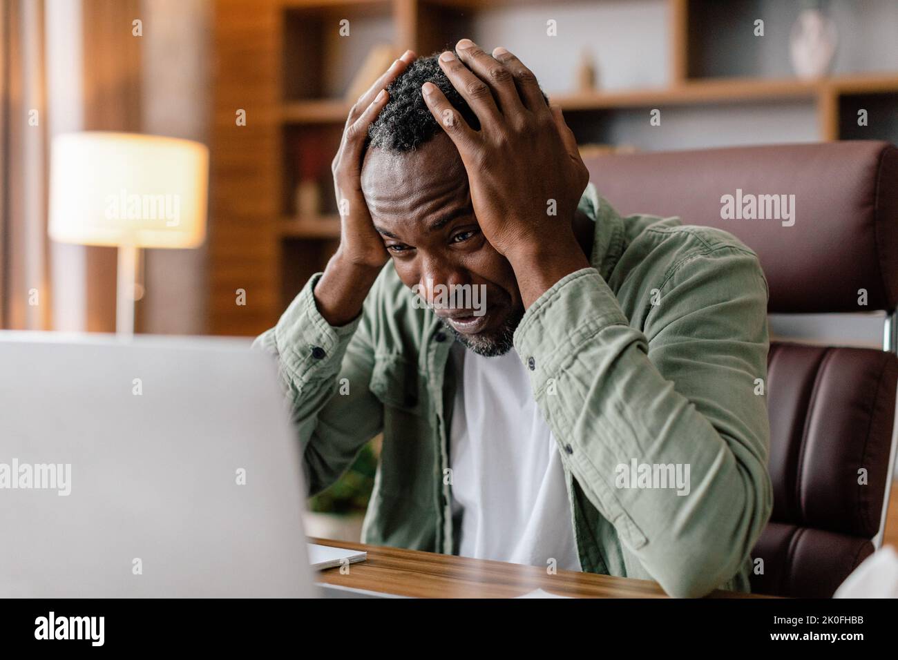 Sad frustrated adult african american guy in casual hold his head with ...