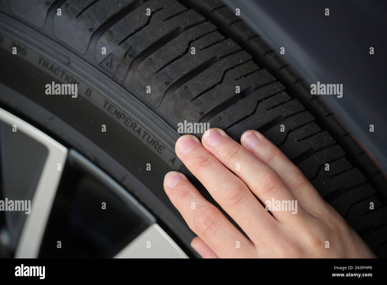 Female driver hands inspecting wheel tire of her new car. Vehicle ...