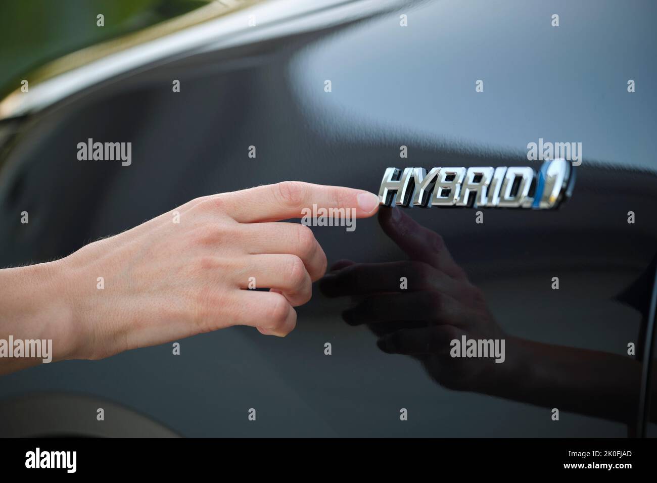 Human hand showing hybrid car sign on new effective vehicle Stock Photo ...