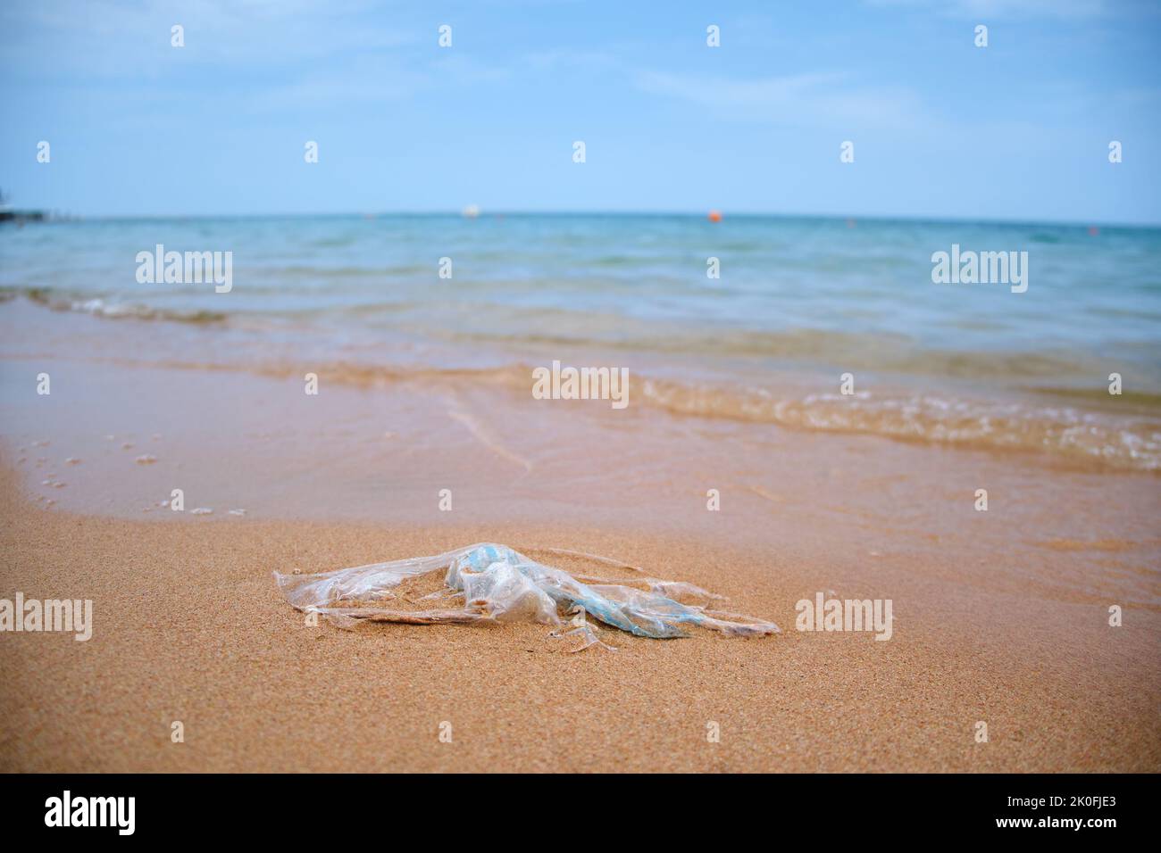 Left behind plastic bag garbage on sandy beach. Empty used dirty litter ...
