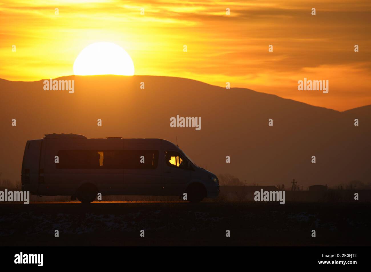Passenger van driving fast on intercity road at sunset. Highway traffic ...