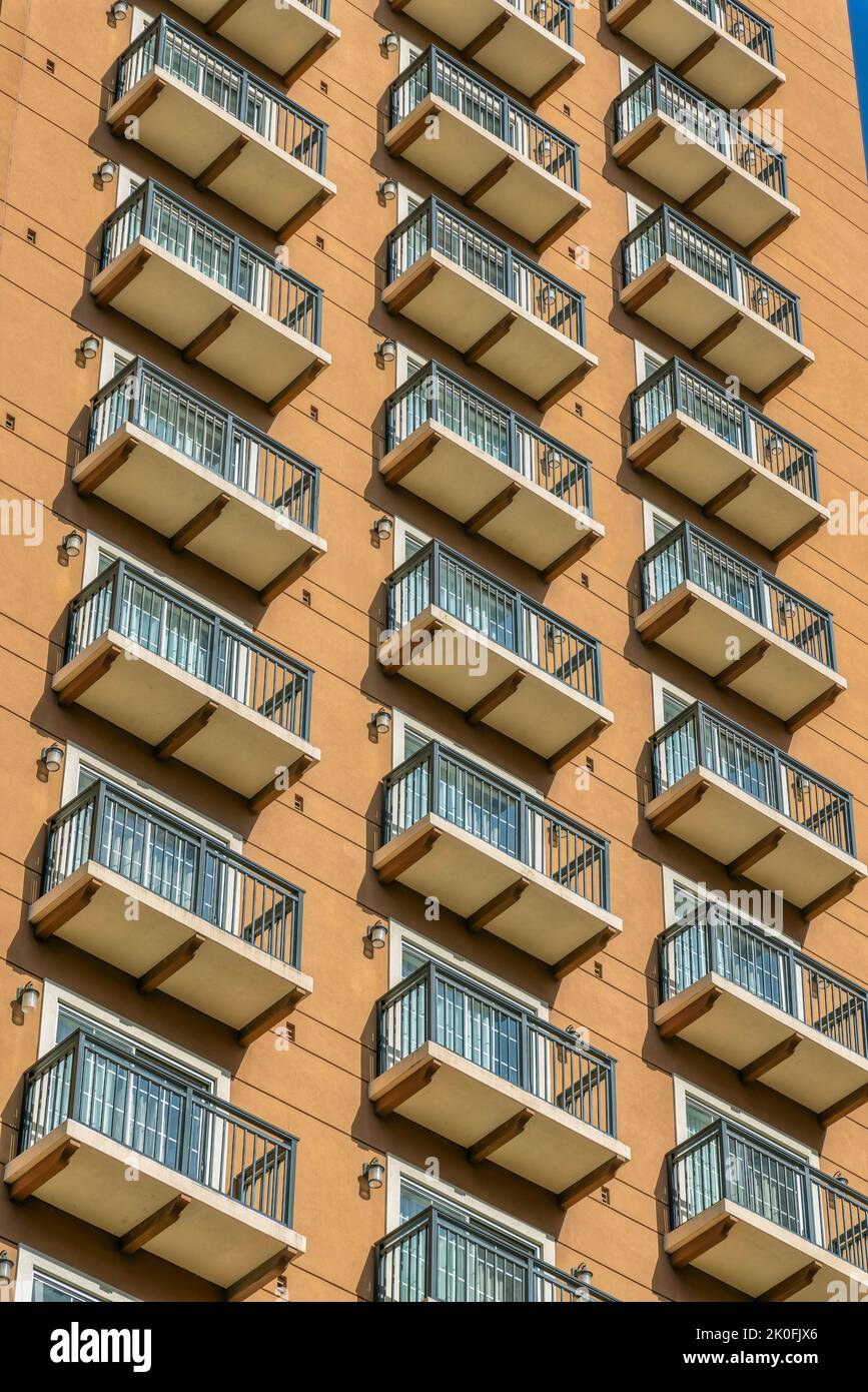 Exterior of apartment building with large glass doors going out to balconies. View from the ...