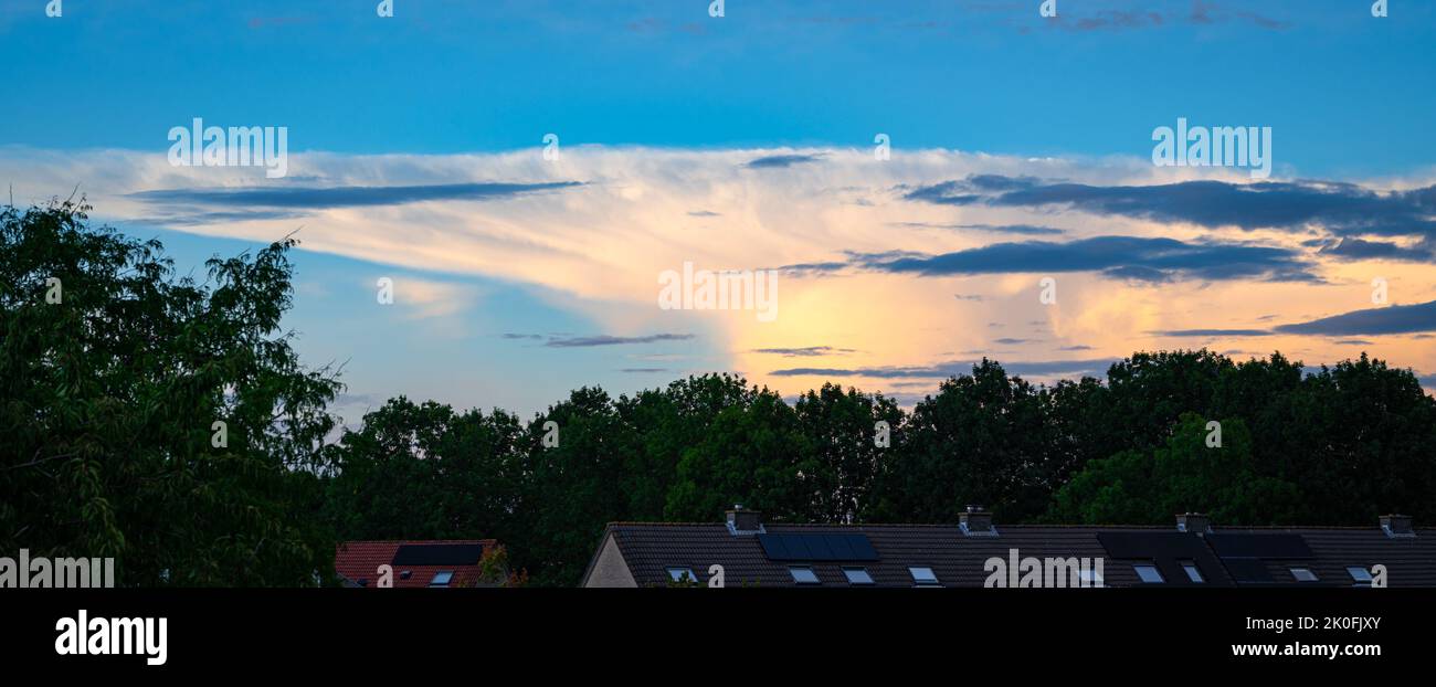 The top of a distant storm cloud is spreading out like an anvil and ...
