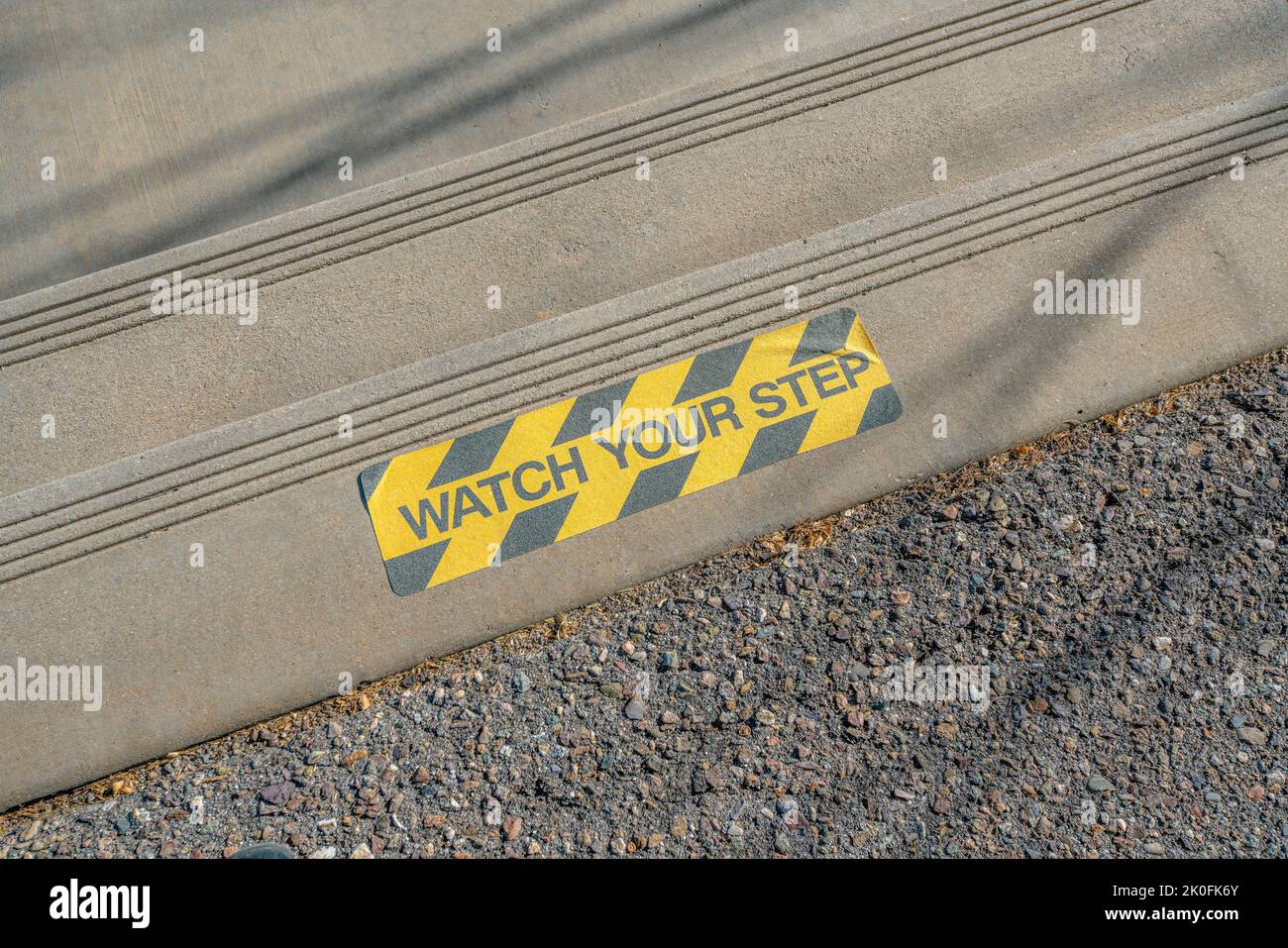 Pasted watch your step sticker sign on a concrete step in Tucson ...