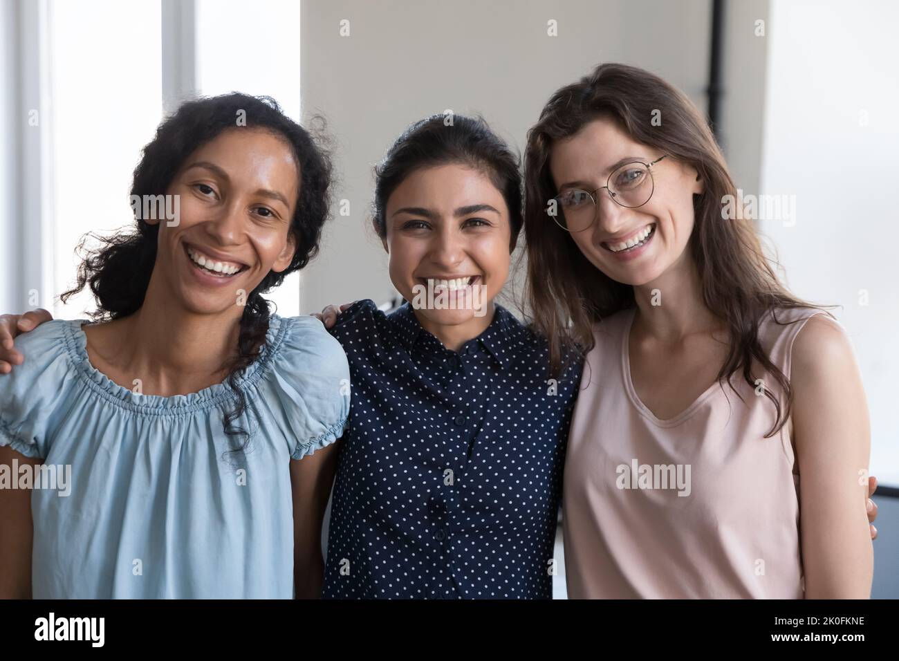 Happy multiethnic team of young women standing indoors Stock Photo - Alamy