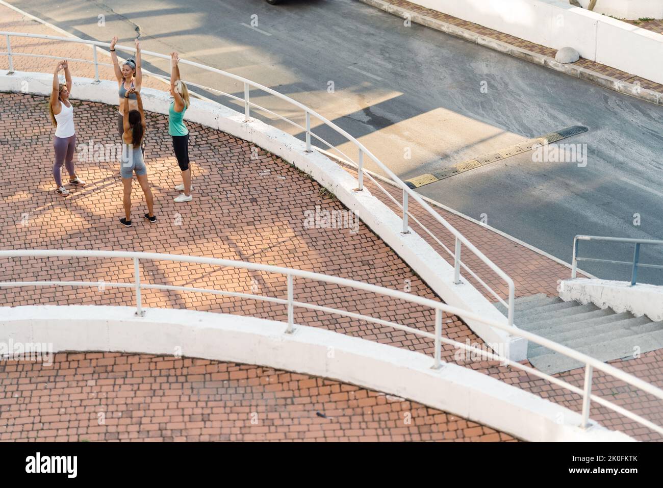 Multiracial women doing exercise while working out on summer day ...