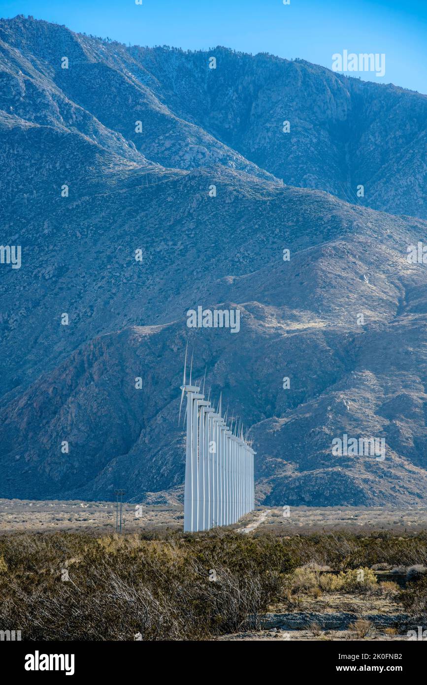 Palm Springs, California- Straight row of wind turbines on a shrubland ...