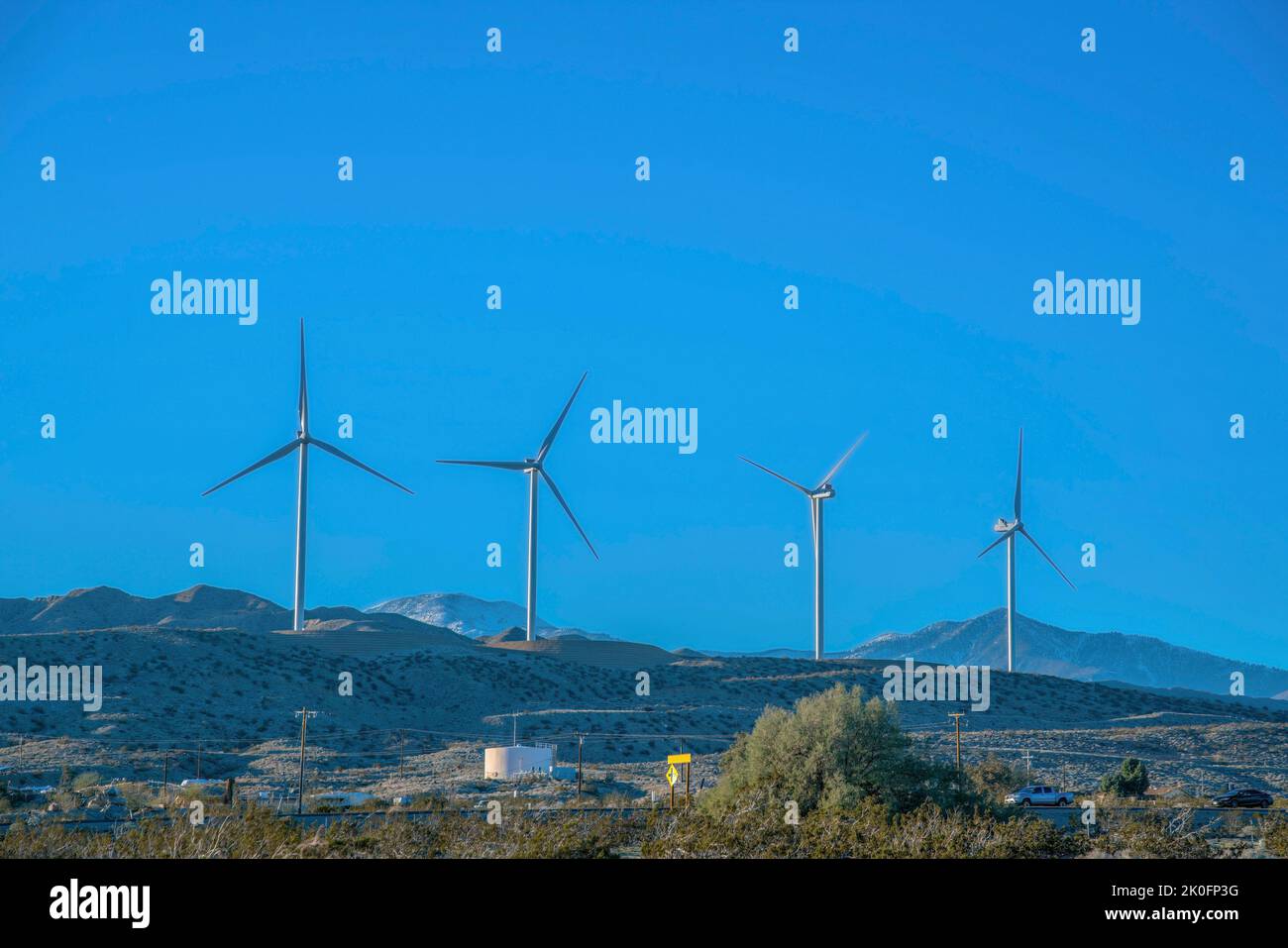 View of wind turbines on a mountain across the highway in a desert at ...