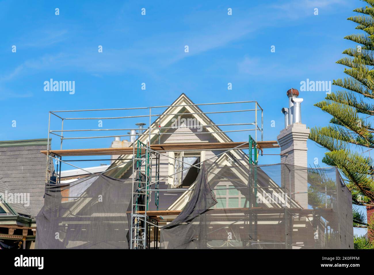 Unfinished house exterior with scaffolding covered with net in San ...