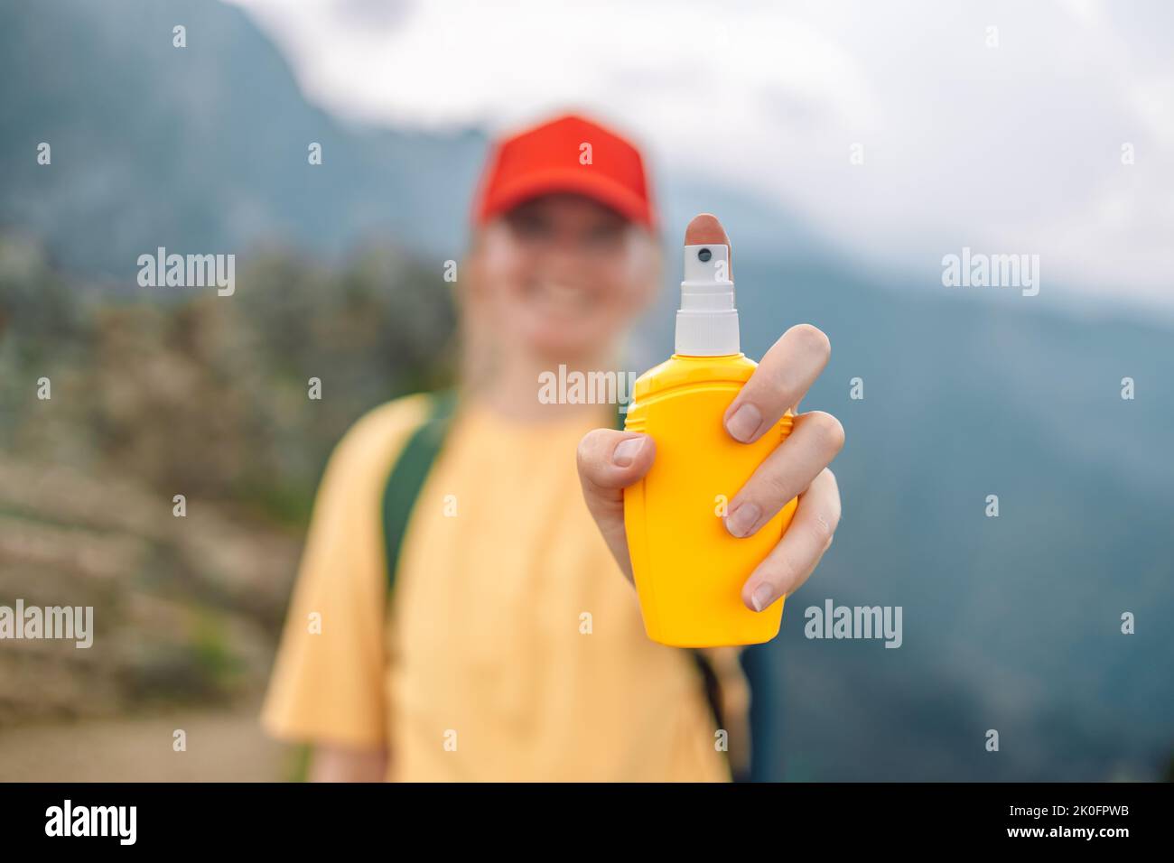 Woman applying insect repellent against mosquito and tick on her hand ...