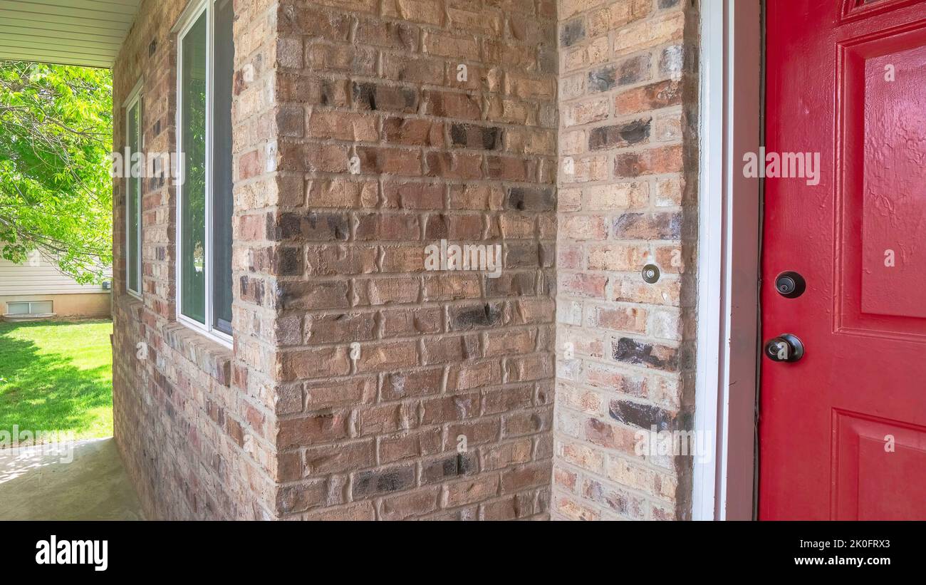 Panorama Porch of a house with bricks and plants at the front. There is ...