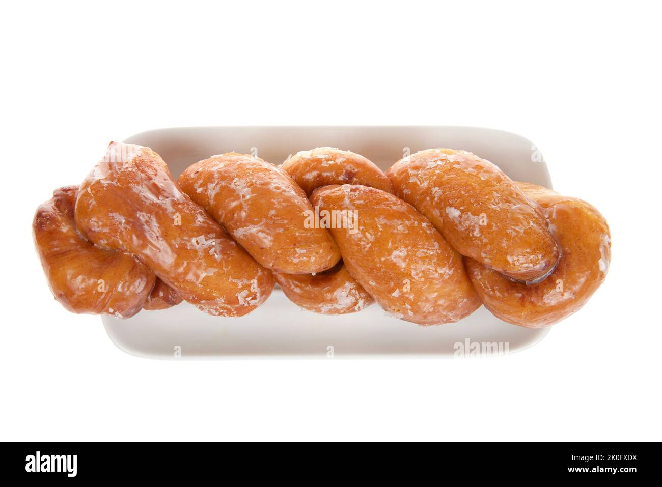 Above top vie of Cinnamon glazed twist donut on rectangular porcelain ...