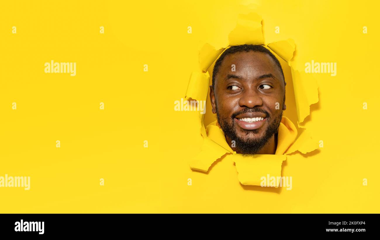 Happy black man looking aside at free space and smiling, noticing ...