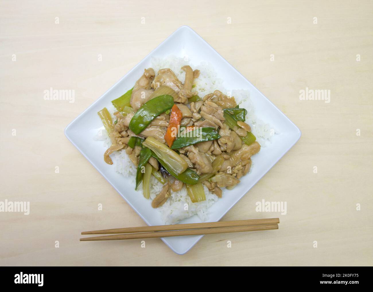 close up flat lay top view of a square plate with Almond Chicken over ...