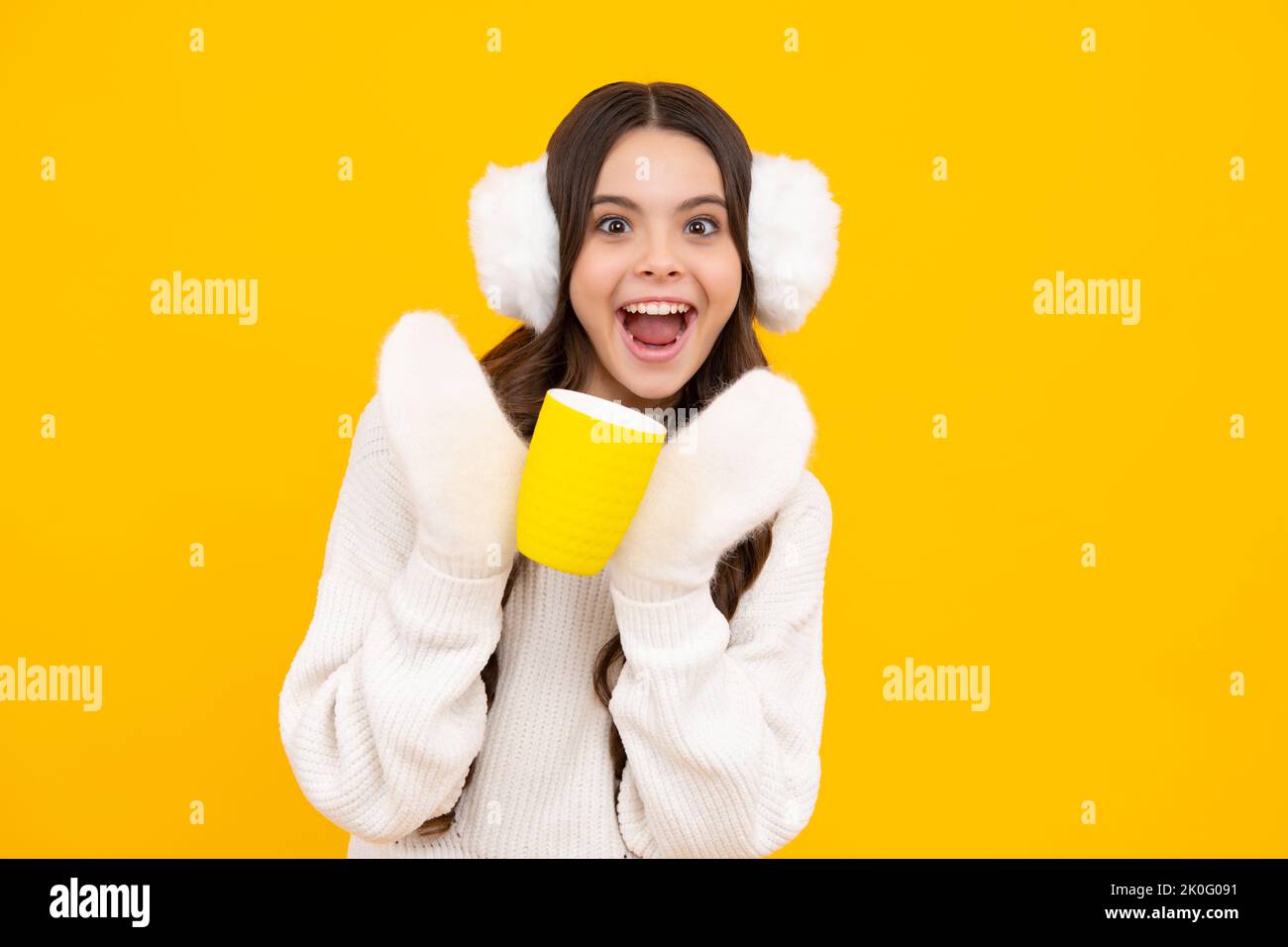 Excited teenage girl in winter warm earmuff ear-flaps and sweater with ...