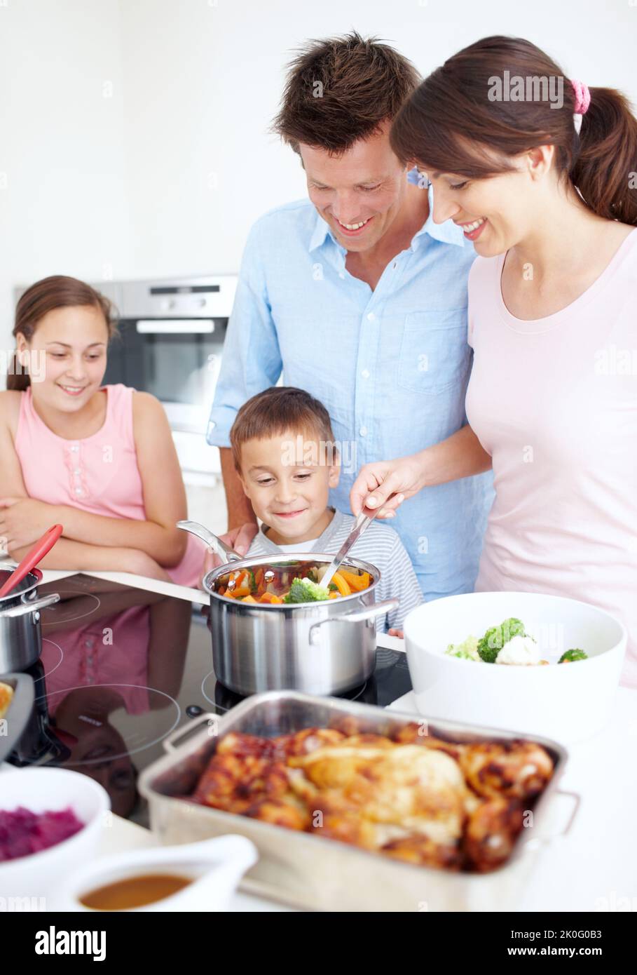 An enthusiastic family in the kitchen. A happy family cooking a large ...
