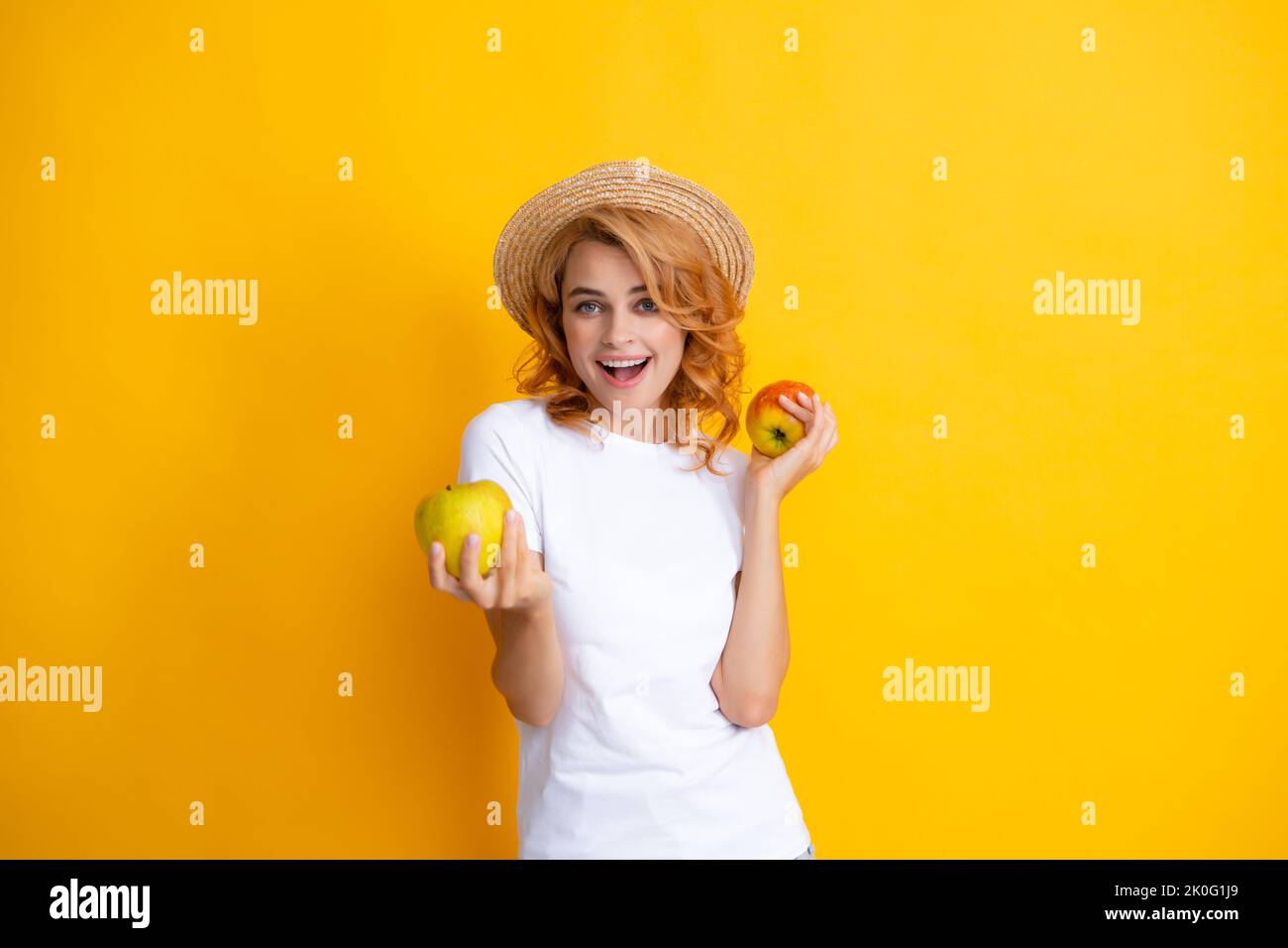 Young woman holding apples smiling with a happy and cool smile on face ...