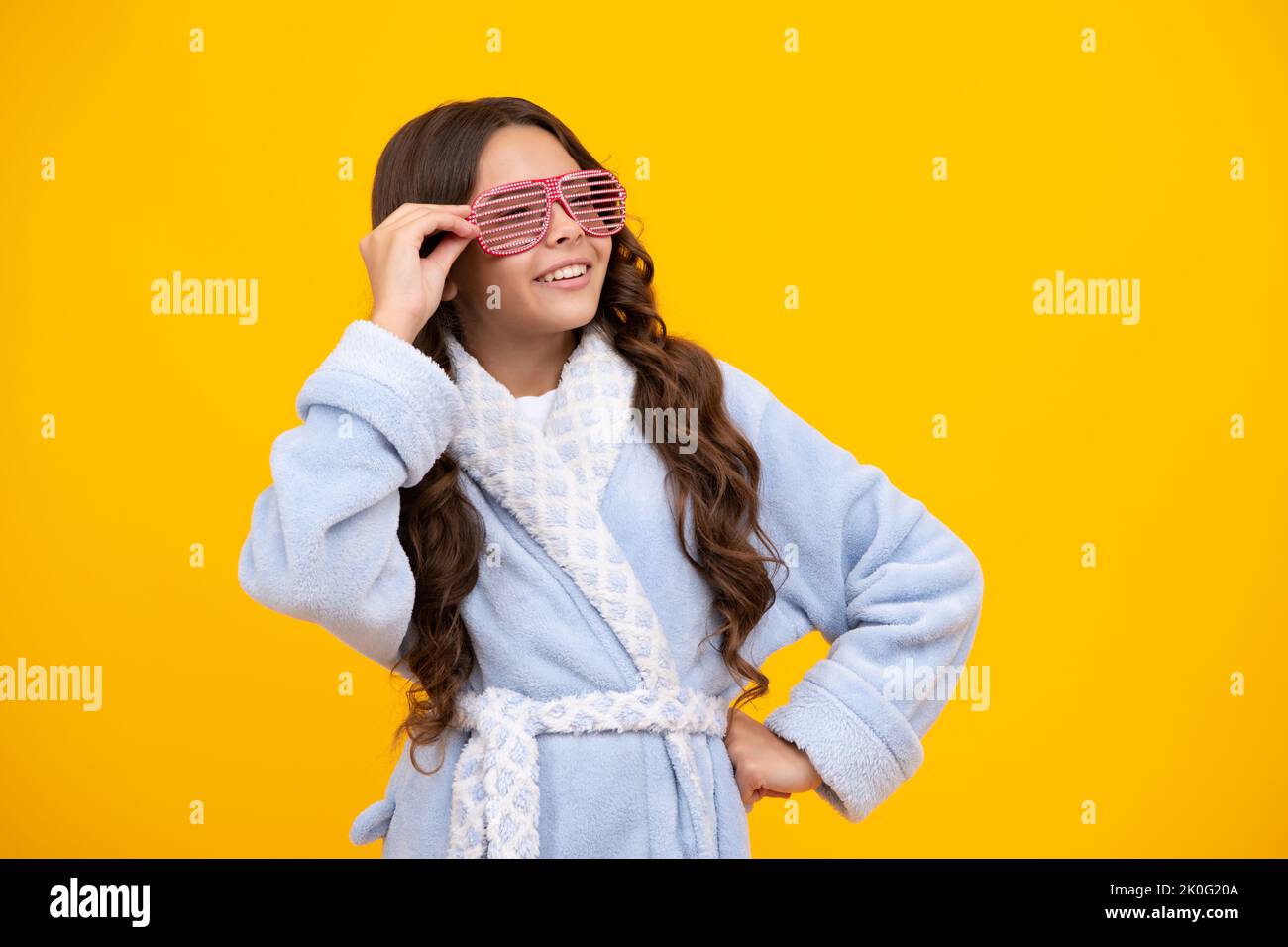 Portrait of teenage girl in funny glasses and pajama or home bathrobe ...