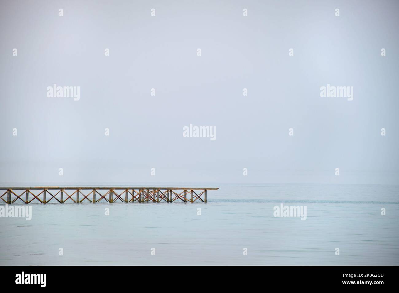 Long horizontal pier bridge on blue sky and water copyspace background ...