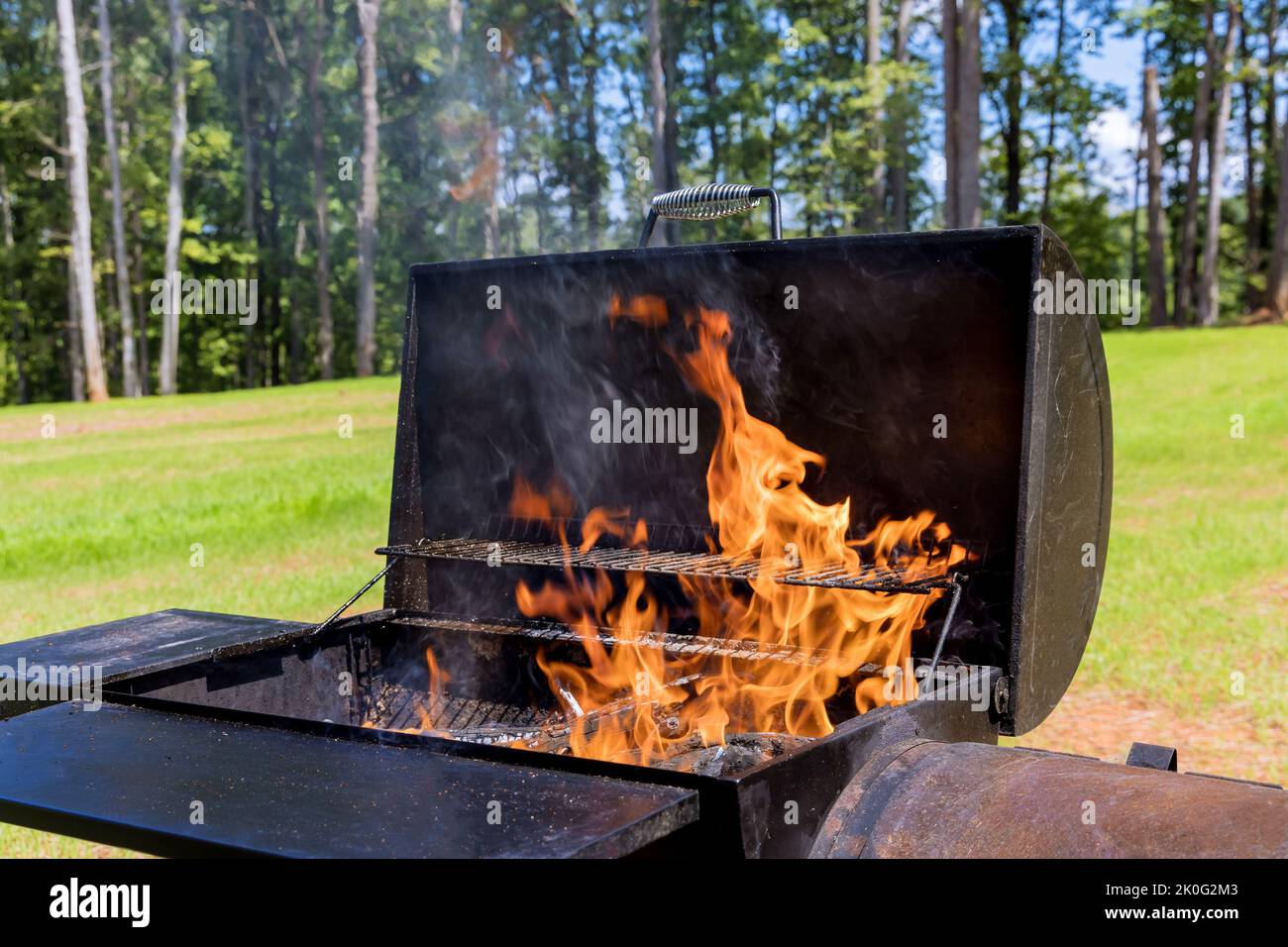 Using firewood with blazing fires for the preparation of a BBQ for ...