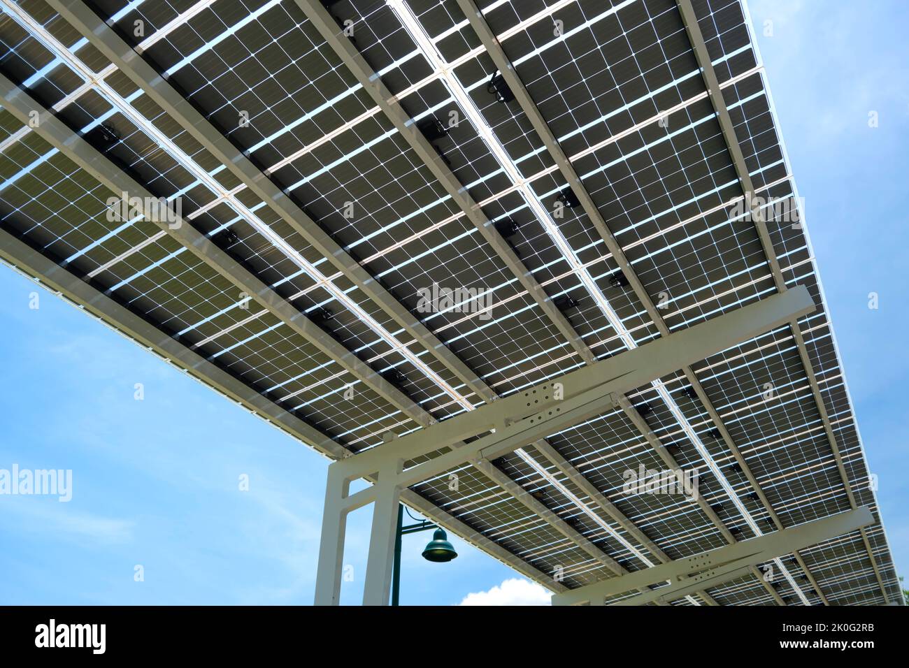 Solar panels installed as shade roof over parking lot for parked ...