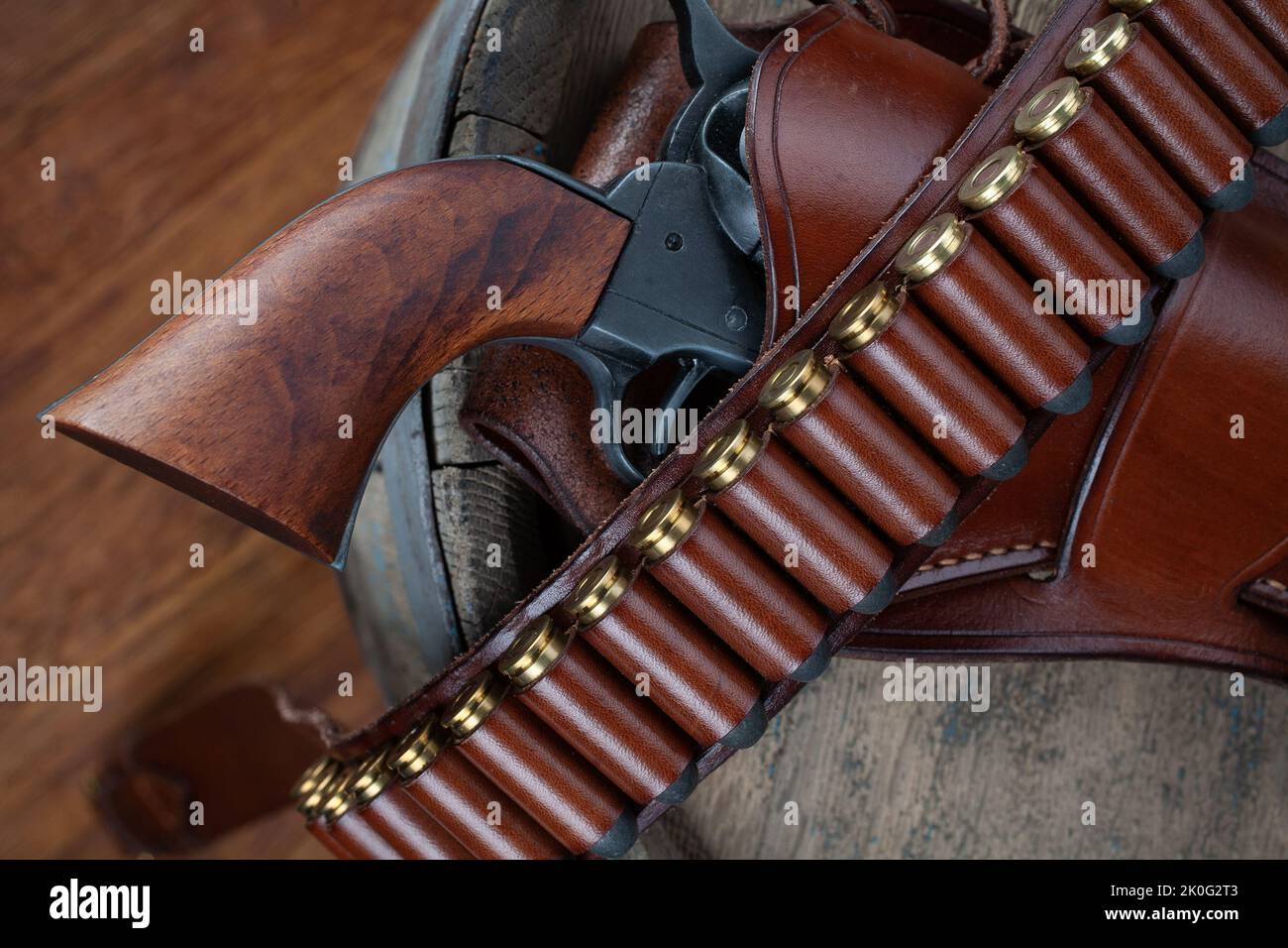 Wild west gun with belt, holster and ammunition on wooden table Stock ...