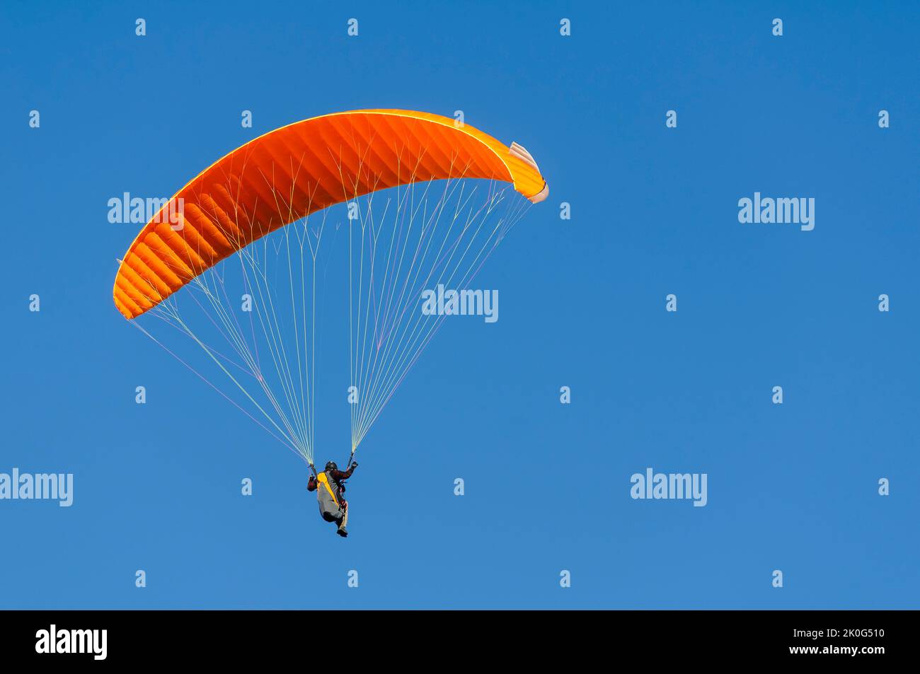 Paragliding orange flying against blue sky. Adventure sport Stock Photo ...