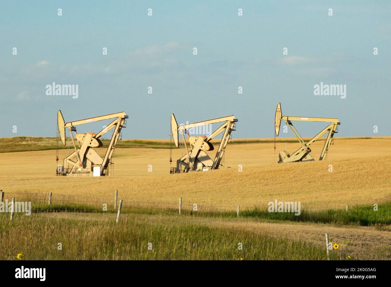 Industrial scene showing oil wells pumping oil with three working ...