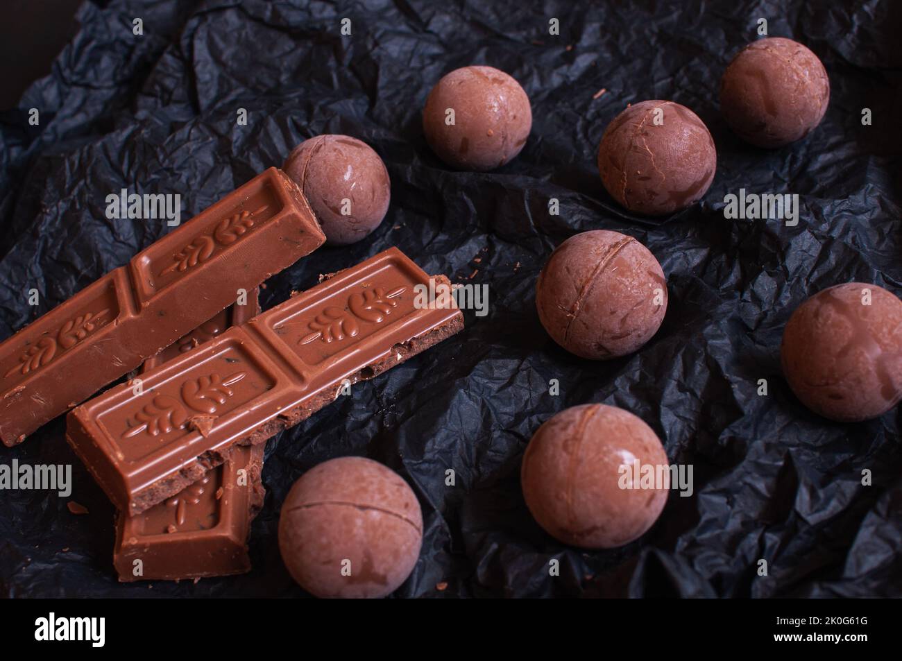 chocolate round candies with chocolate pieces on dark crumpled craft ...