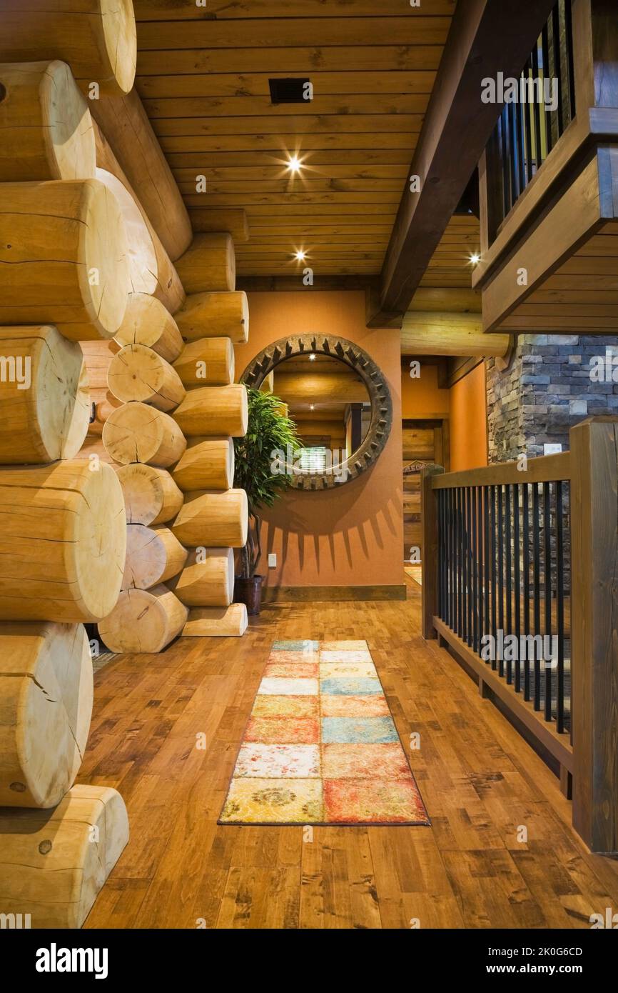 Hallway with large round mirror and colourful runner on the ground ...