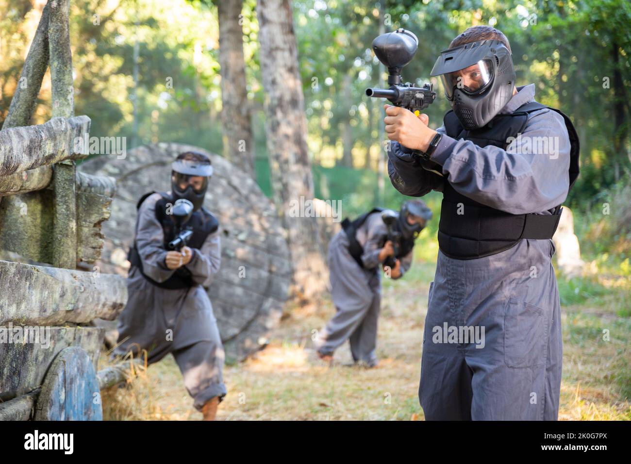 Paintball players aiming and shooting with guns at opposing team Stock ...